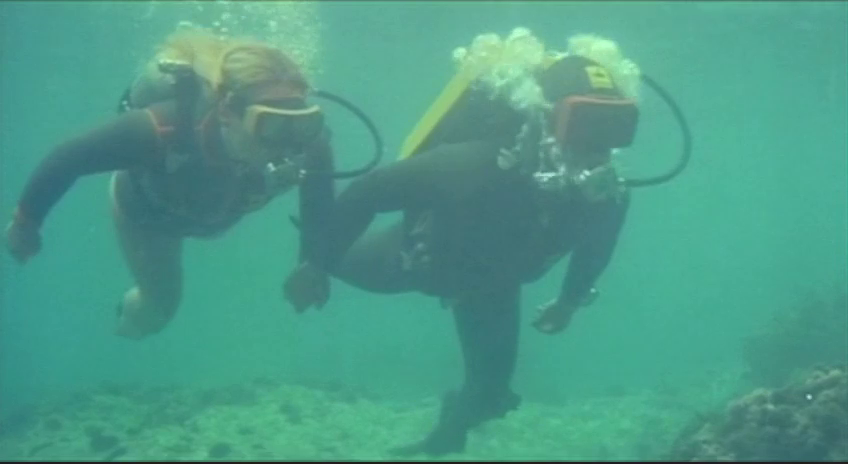 2 frogwomen and 2 frogmen in vintage scuba gear [....and one gets stuck ...